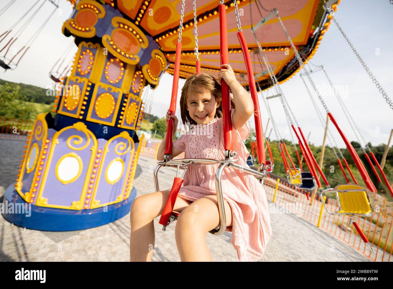 Kids riding on colorful amusement carousel Stock Photo - Alamy
