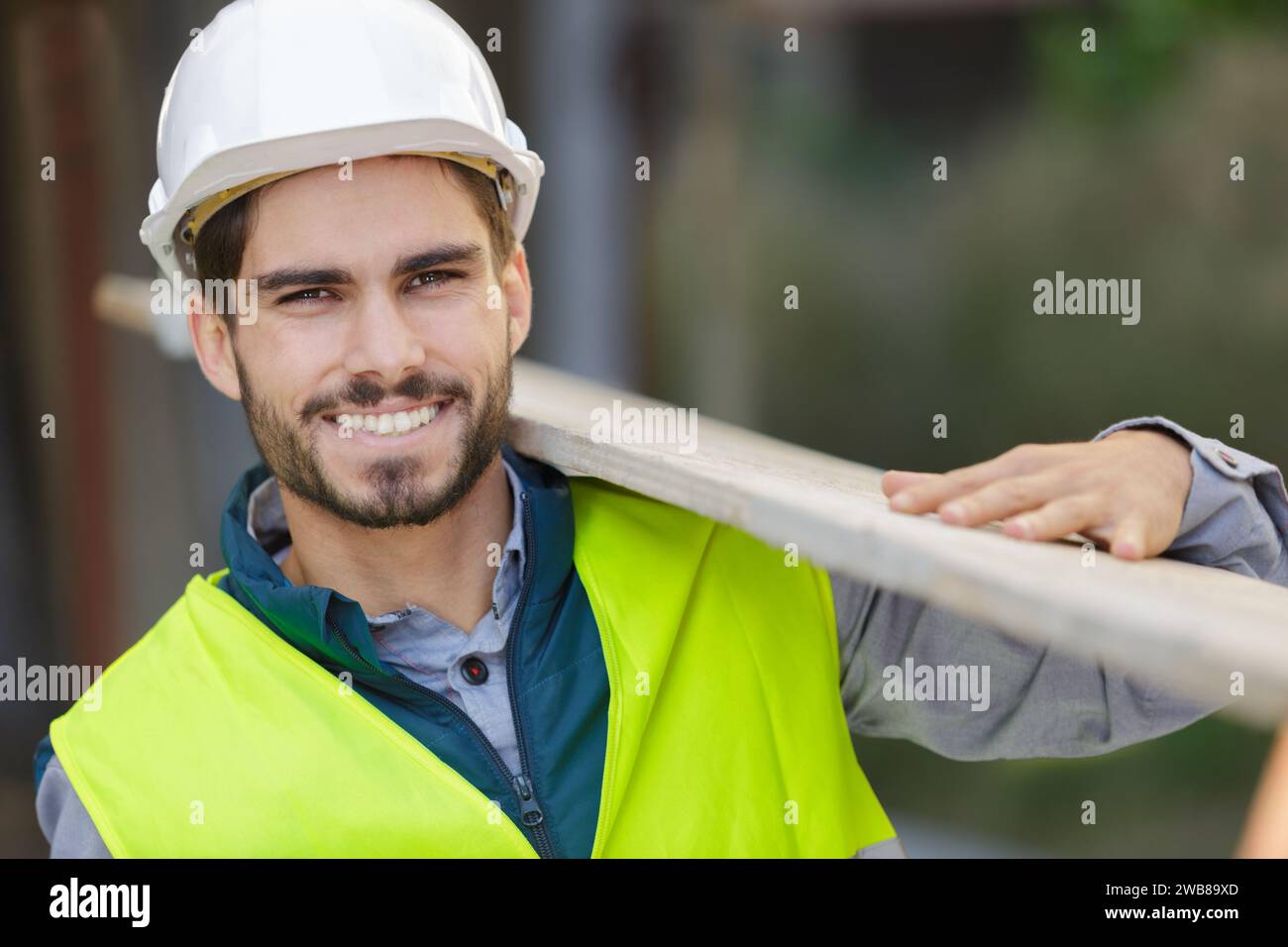 happy man as builder carrying wood and working Stock Photo - Alamy