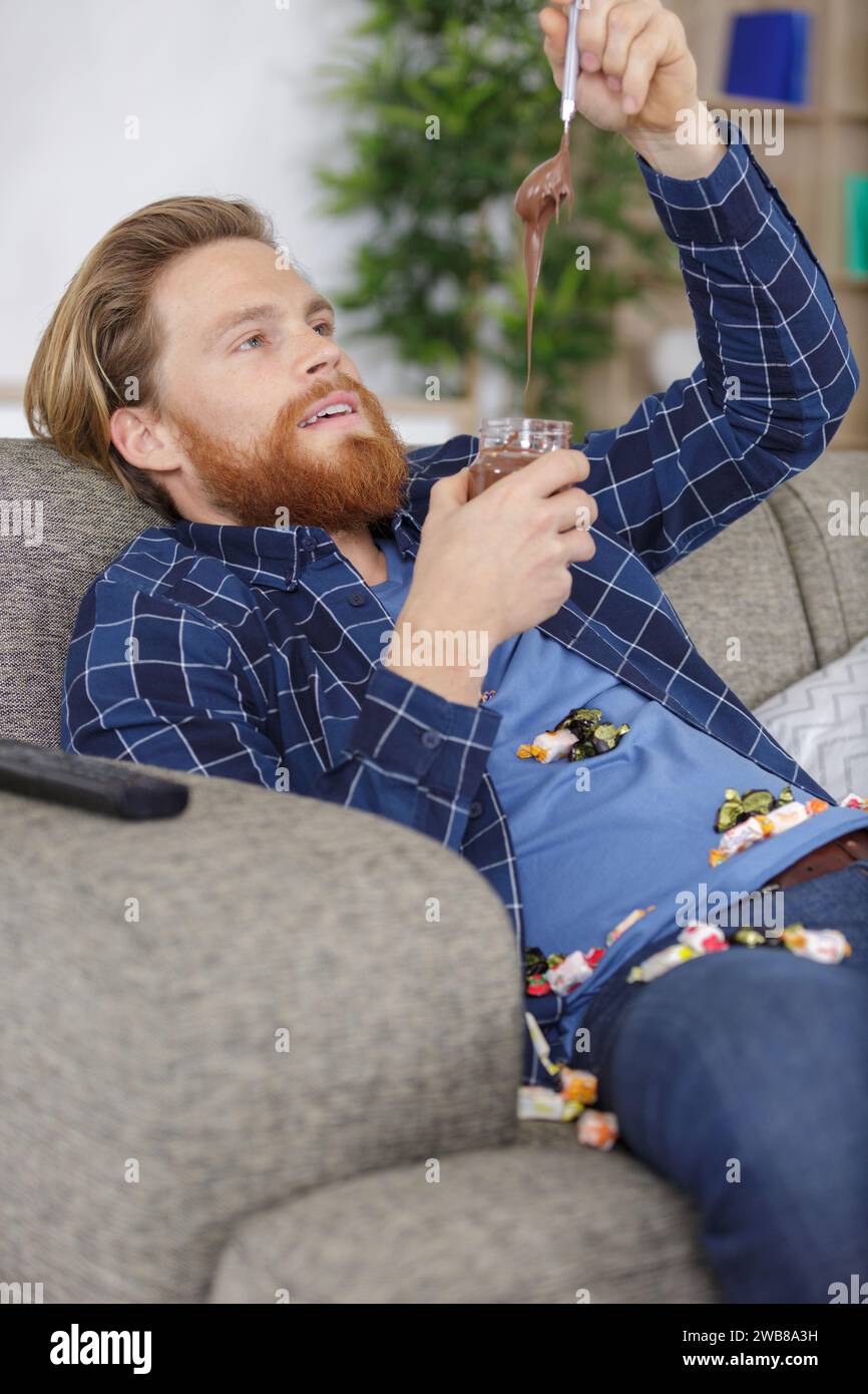 man covered in sweets eating chocolate spread from the jar Stock Photo ...