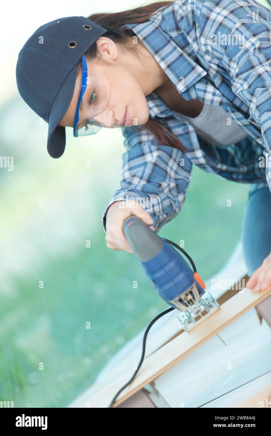 young female floor fitter using a jigsaw cutter Stock Photo - Alamy