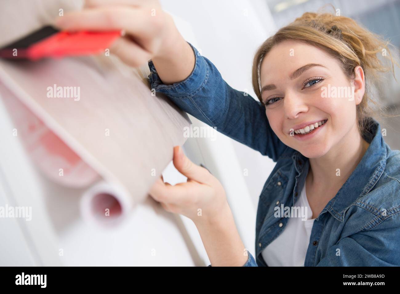 happy woman applying glue on wallpaper Stock Photo - Alamy