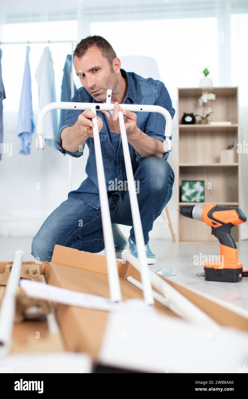 man assembly furniture from box with instruction on white paper Stock ...