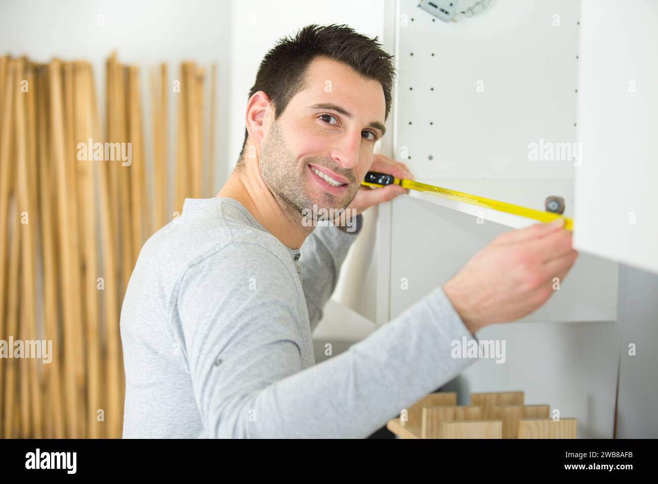 a man measuring cupboard width Stock Photo - Alamy