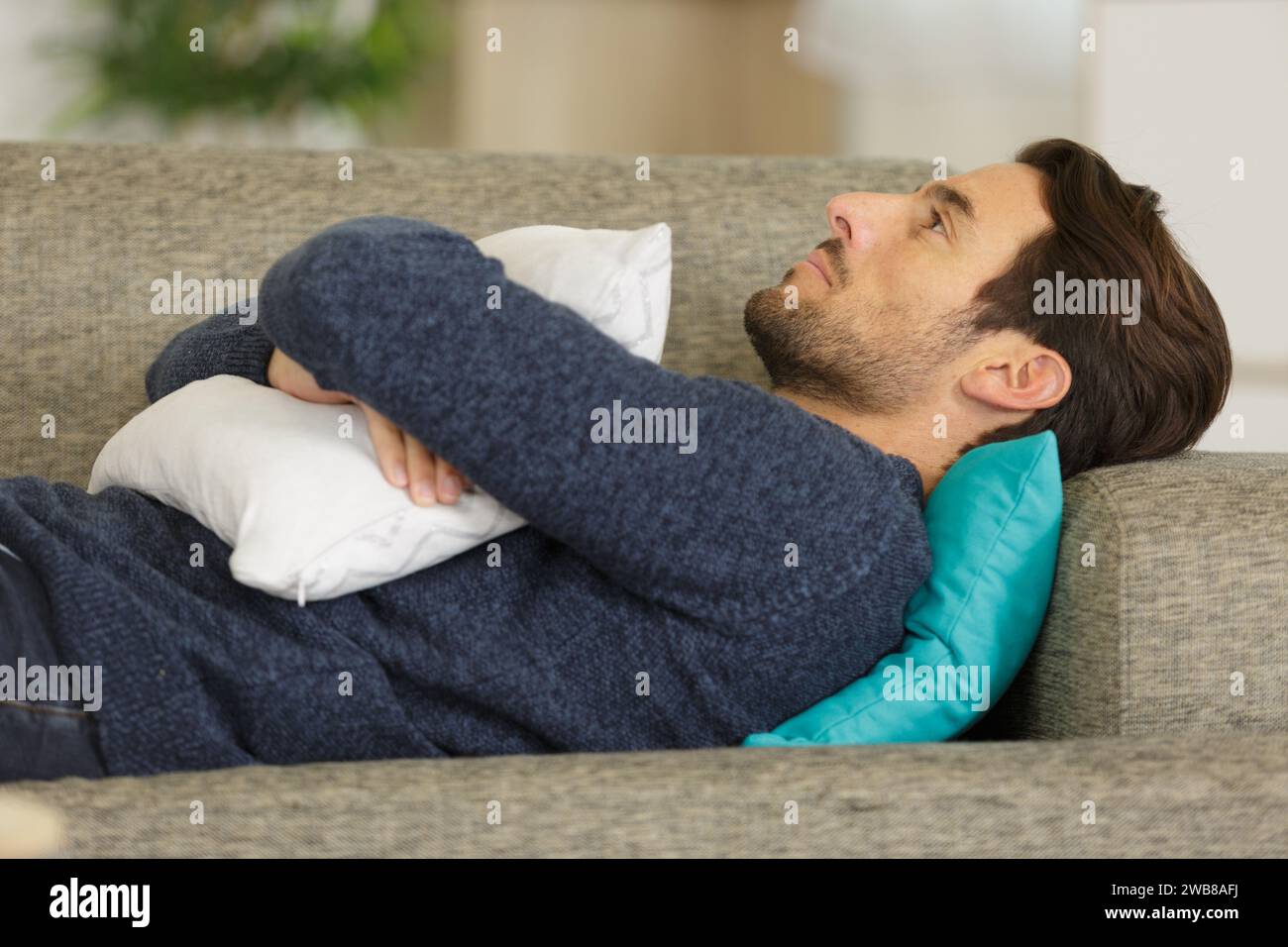 Depressed man laying on sofa hi-res stock photography and images - Alamy
