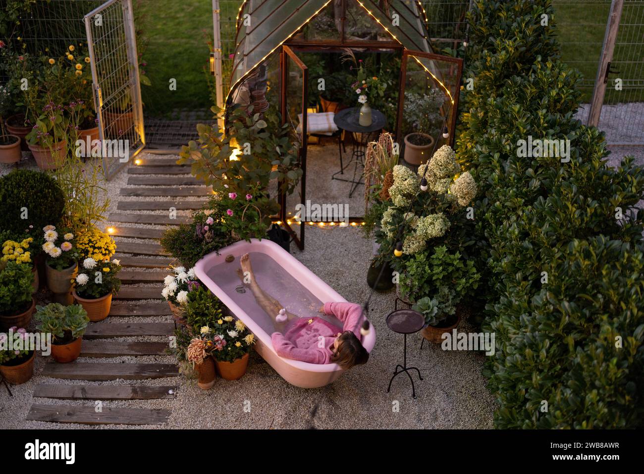 Cozy backyard with a woman bathing in pink bathtub Stock Photo - Alamy