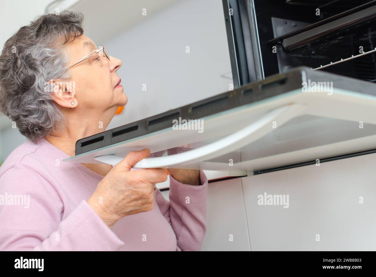 happy matured woman opening oven Stock Photo - Alamy
