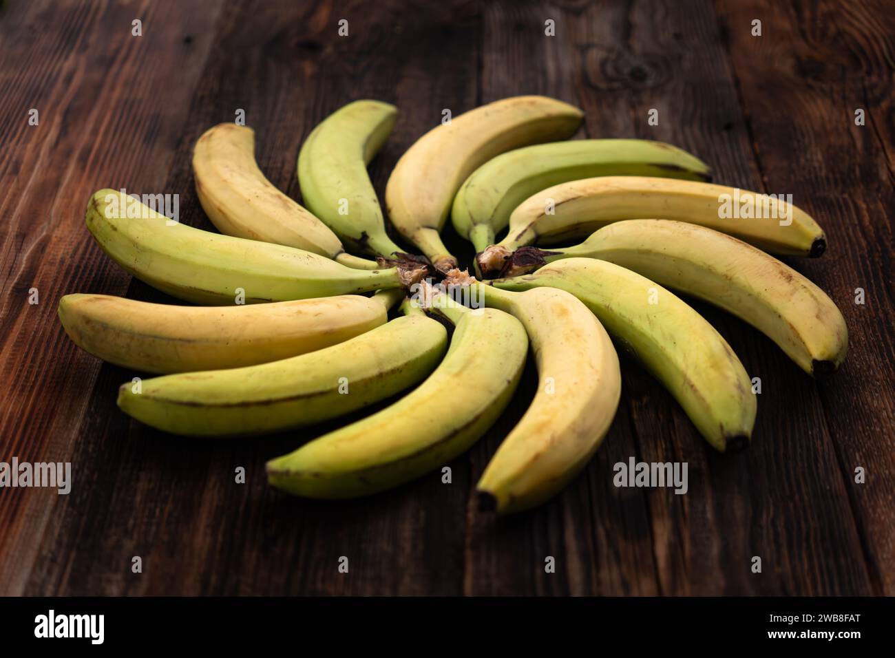 Bananas on brown wooden table top view. Figured position of bananas in ...