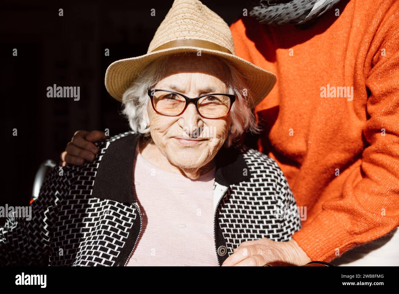 Portrati of a smiling ninety three years old woman with a straw hat ...