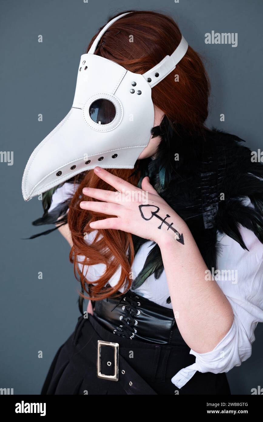 A female cosplayer dressed as a plague doctor with a white mask Stock ...