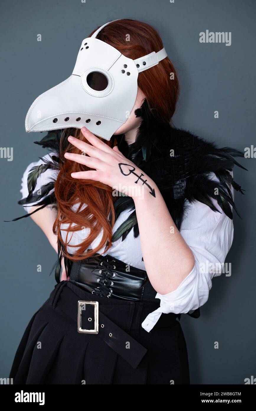 A female cosplayer dressed as a plague doctor with a white mask Stock ...