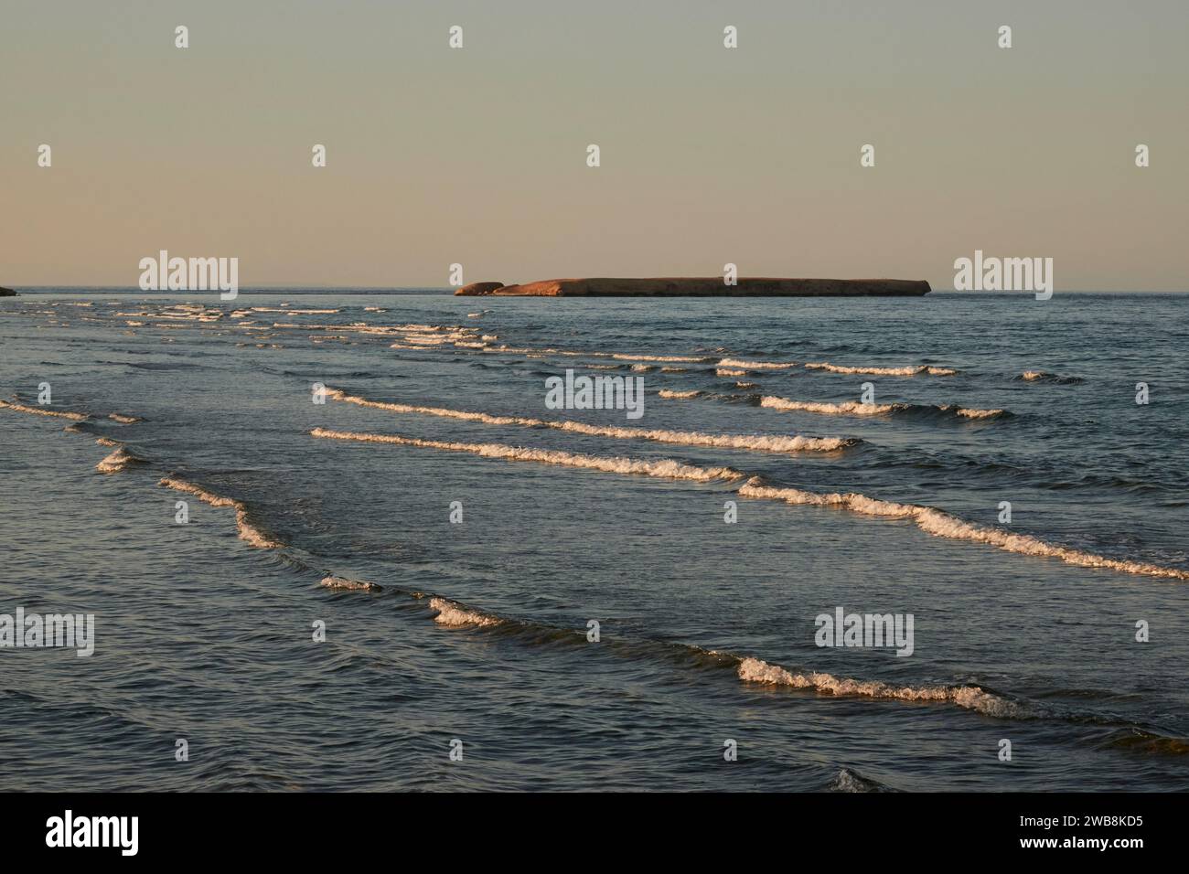 A serene Red Sea beach landscape with small waves lapping against a ...