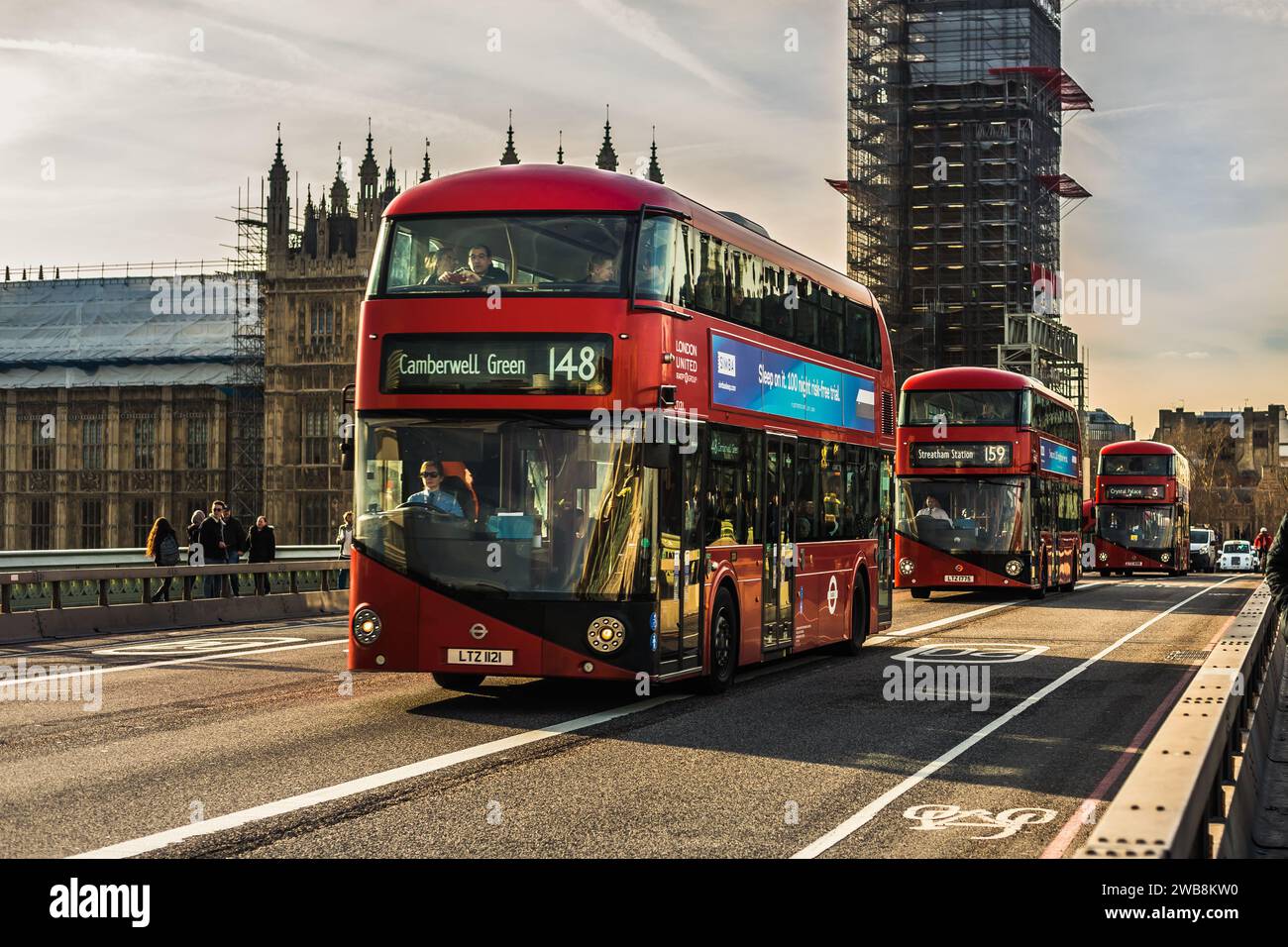 Red buses on the London Bridge, Westminster in the background, England ...