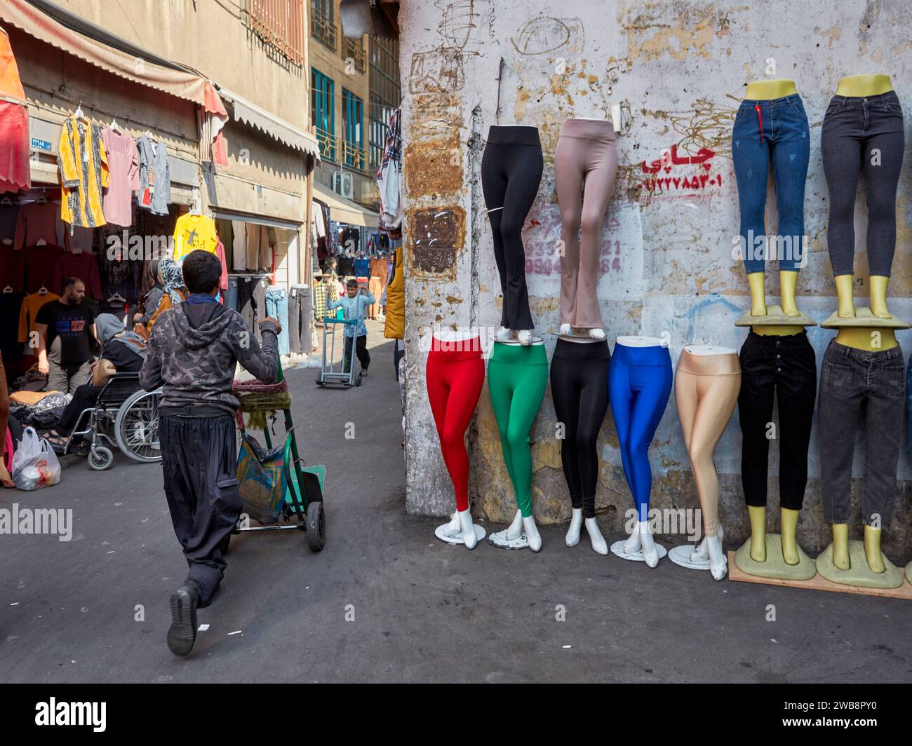 A porter passes by a display of women’s pants and leggings on female ...
