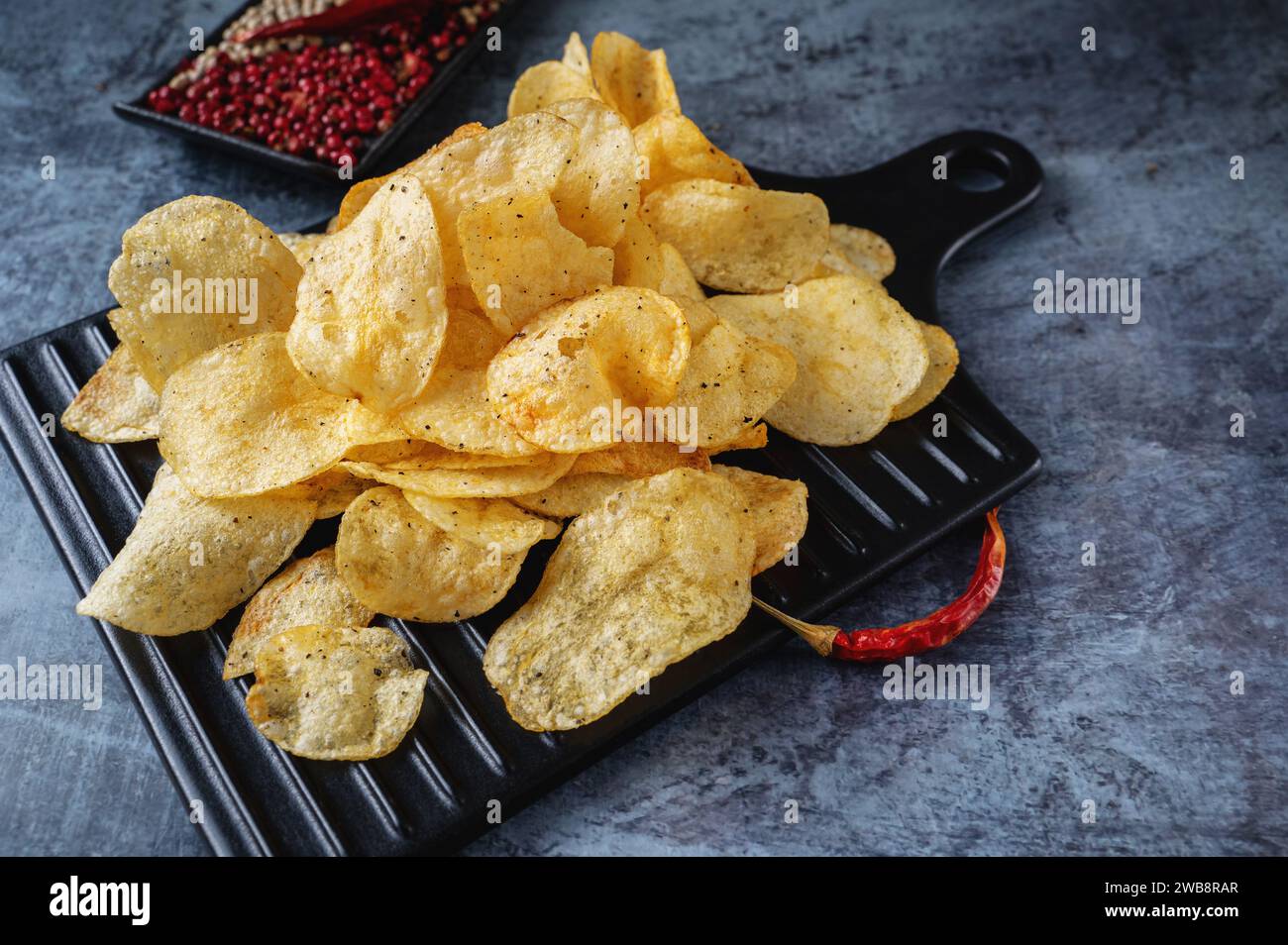 Potato spicy chips in a handmade clay bowl with peppers. Top view Stock ...