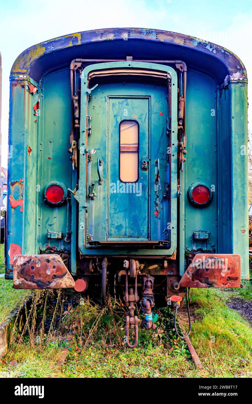 Old blue passenger carriage with front door on disused train tracks at ...
