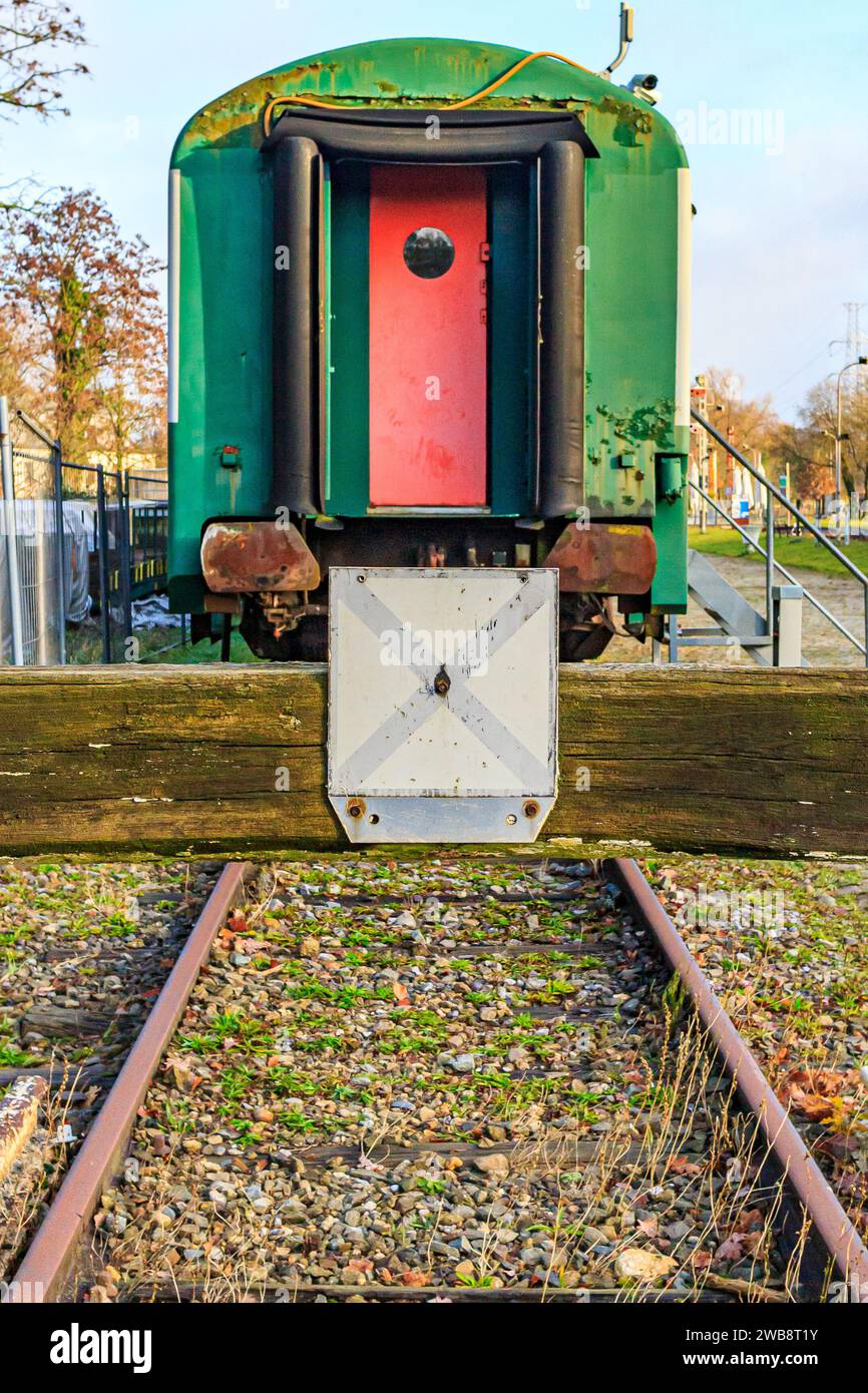Front view of wooden terminal bumper stop with an old train carriage in ...