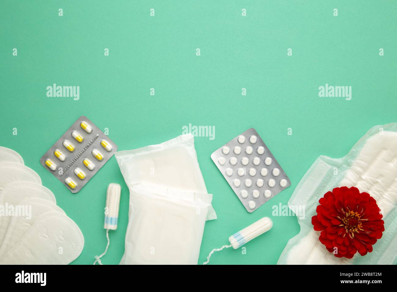Top view of menstrual pads, tampon, and pills for period pain with red ...