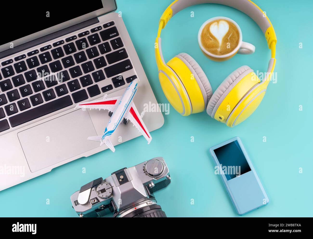 Travel flatlay. Laptop, headphones, mp3 player, camera, plane and ...