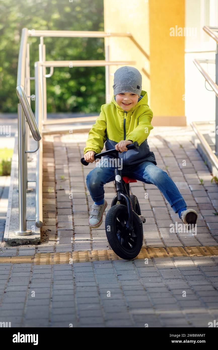 Little boy on a bicycleand downhill acceleration. Caught in motion, on ...