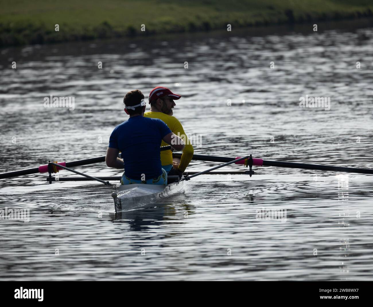Two rowers in double rowing boat on river cam Cambridge with backlight ...