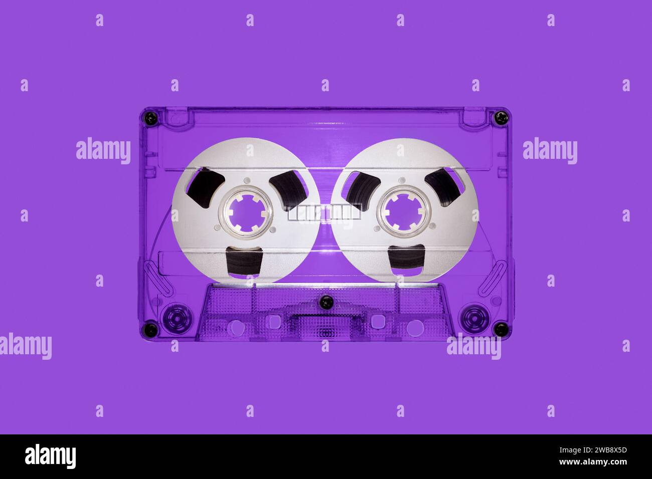 Clear plastic retro audio cassette with spools, isolated on violet ...
