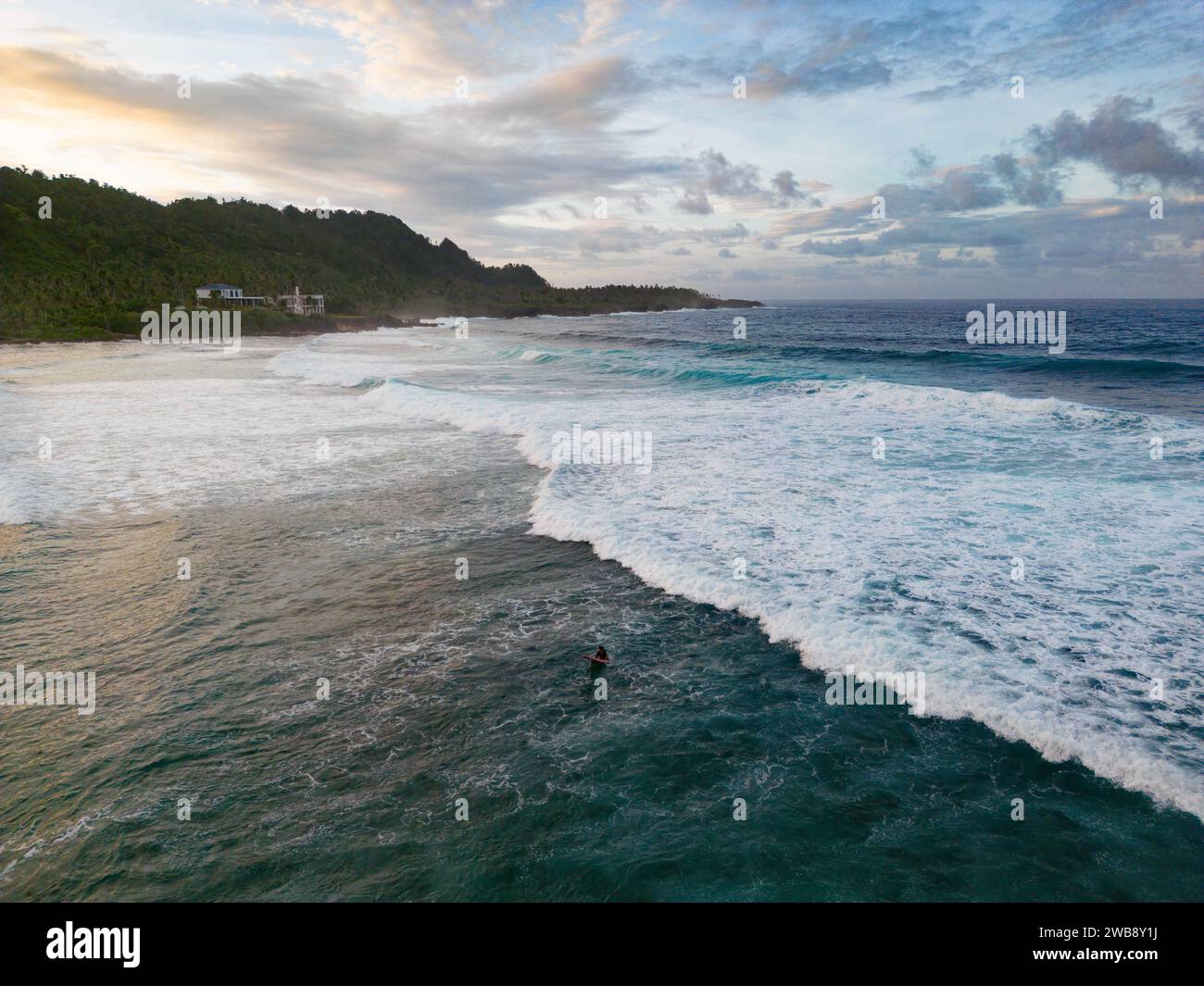 An aerial view of a surfer at Pacifico beach, Siargao, Philippines ...