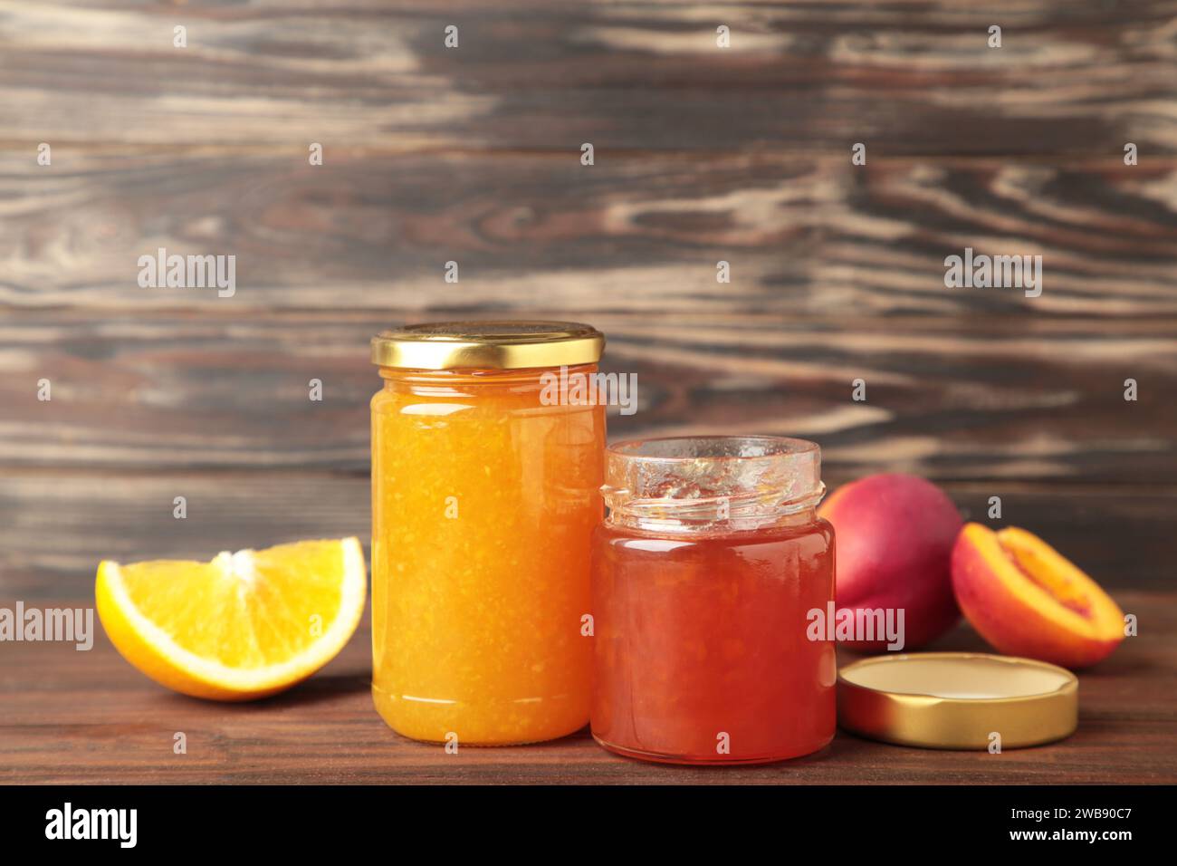 Homemade fruit jam in the jar with fresh fruit and berries on brown ...