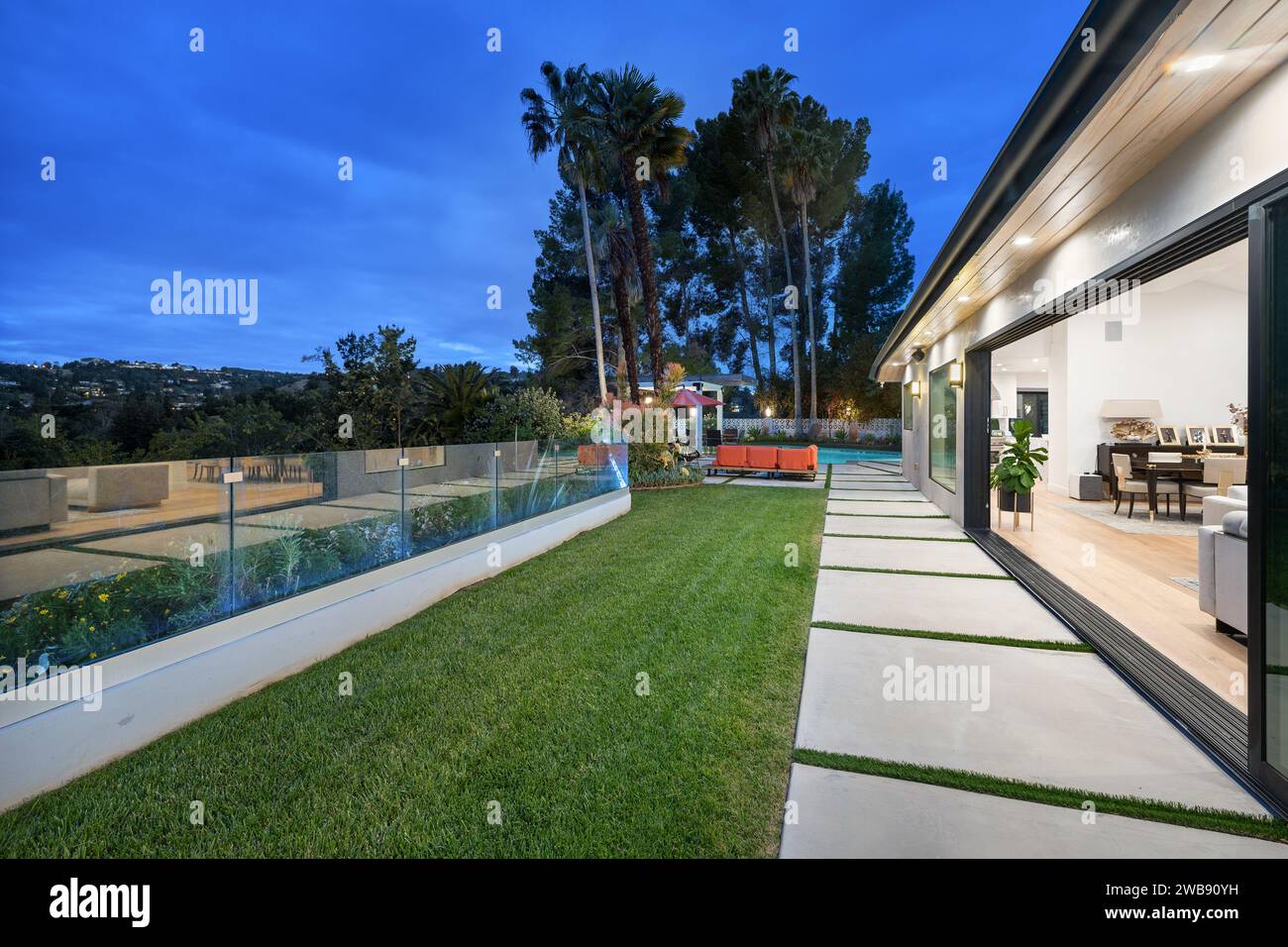An outdoor patio with a transparent glass fence and sliding doors ...