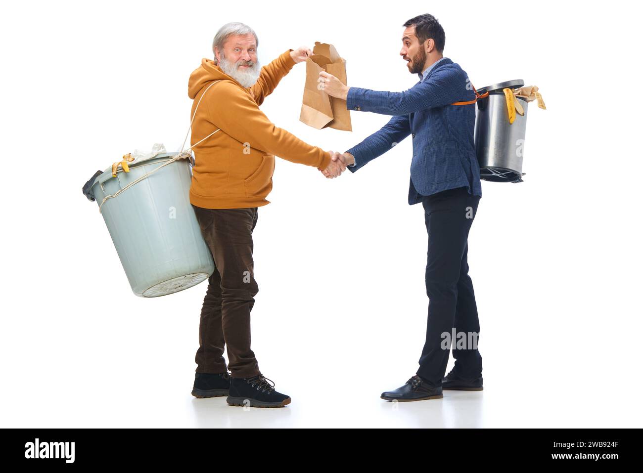 Senior and man in his 30s holding trash bins on backs, shaking hands ...