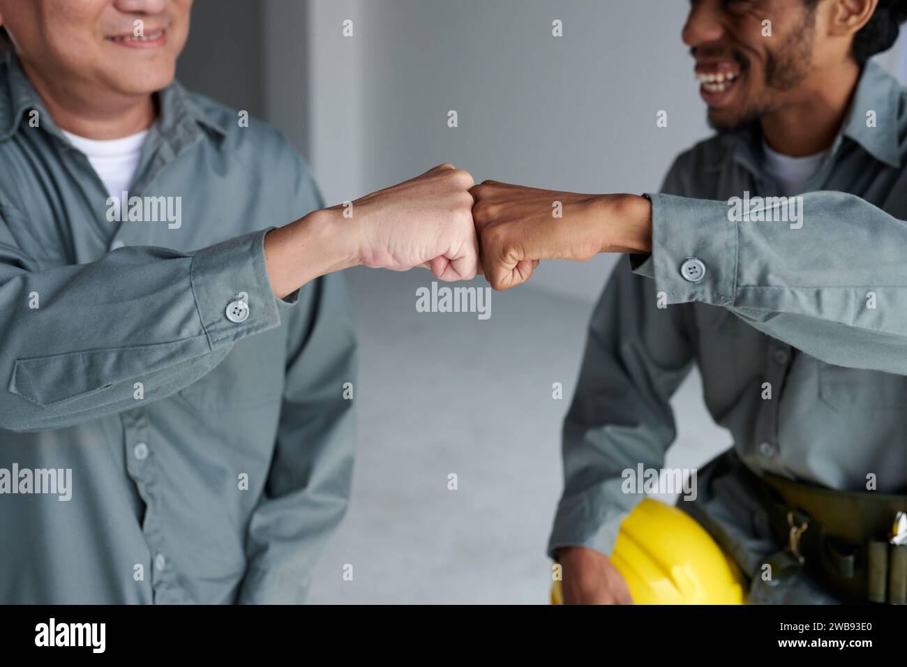 Positive construction engineers making fist bump after finishing day at ...