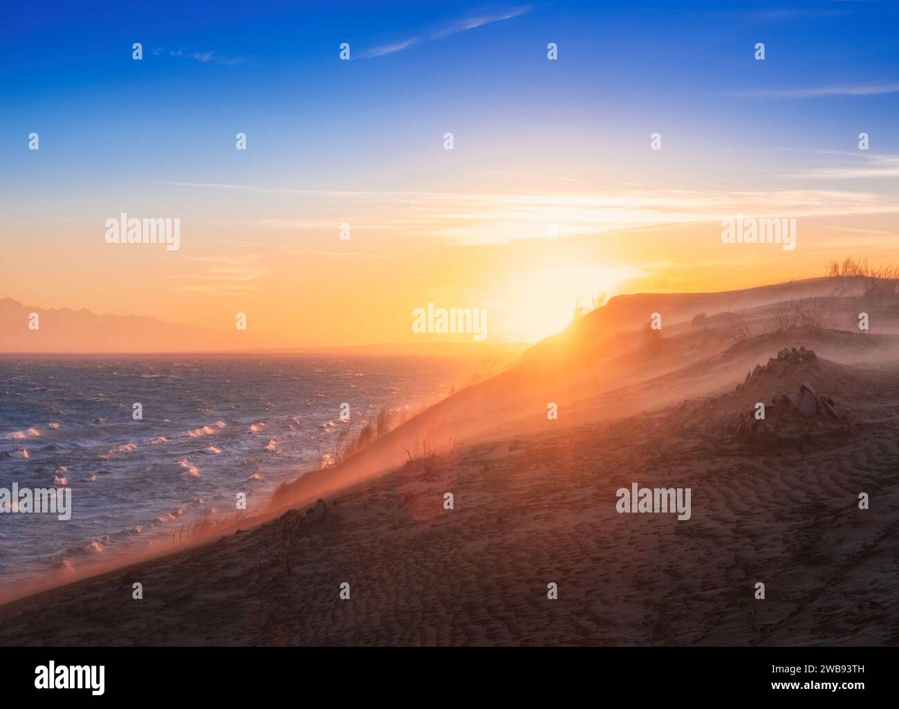 Sea or lake against backdrop of mountains with large sand dunes during ...