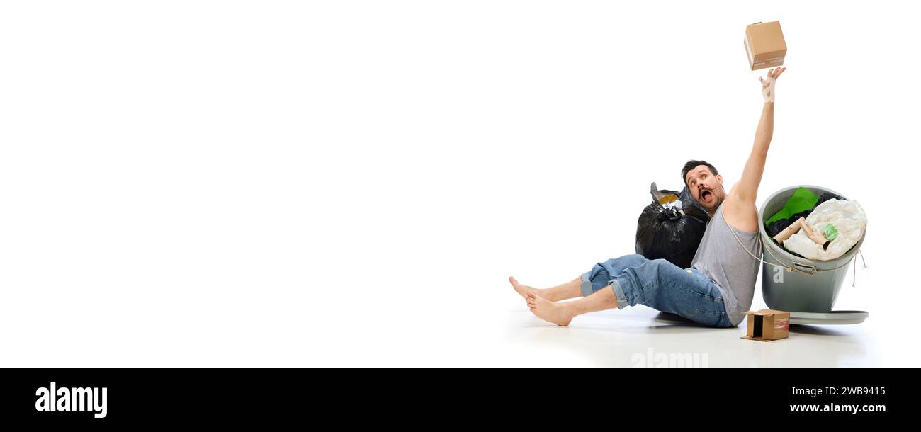 Young man with barefoot lying with garbage and trash bin isolated over ...