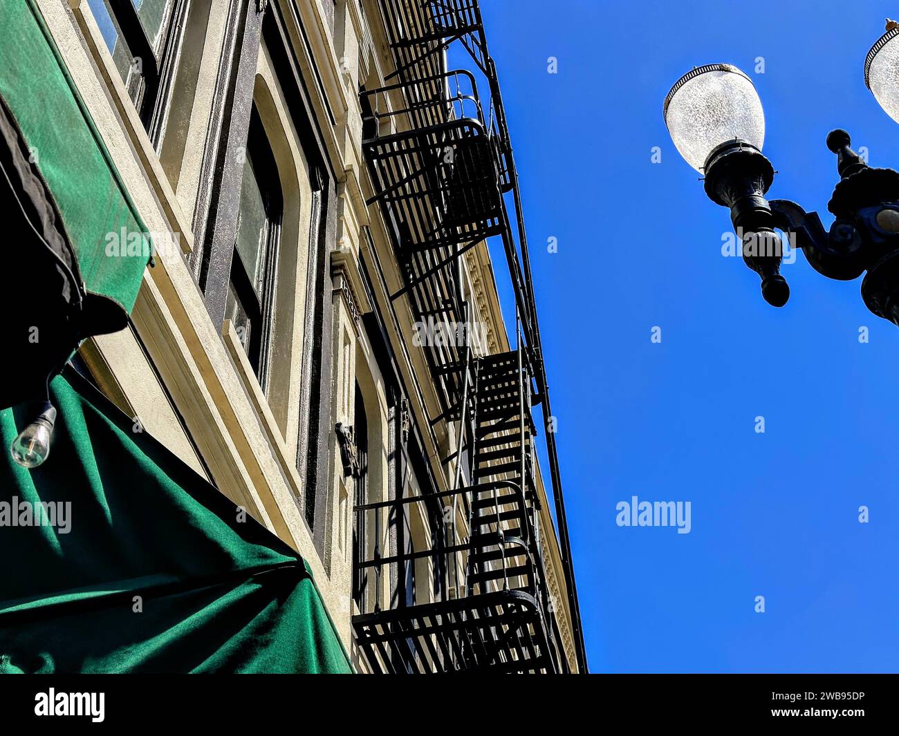 A side of a building is illuminated by light poles and decorated with ...