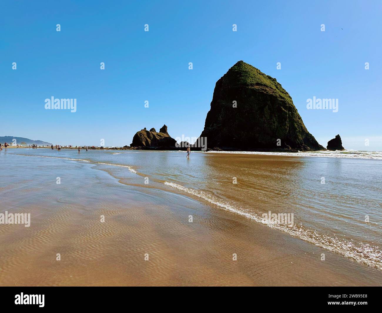 Two mounds of rocks on the edge of a beach, with an outstretched body ...