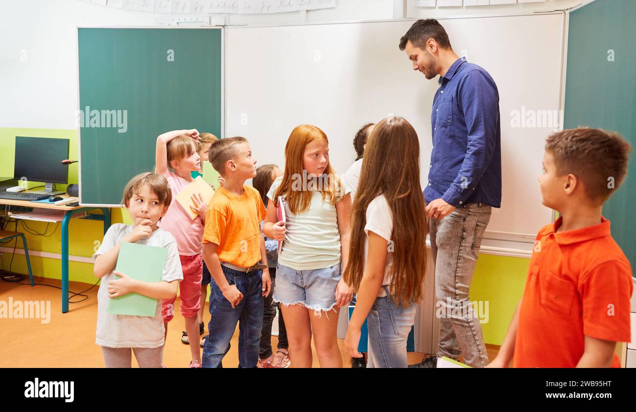 Group of students standing with teacher near whiteboard in classroom ...