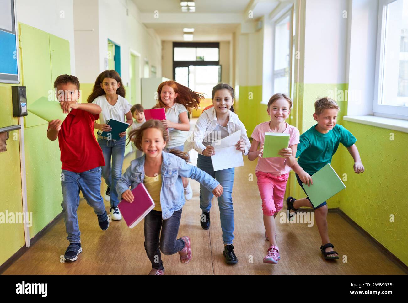 Group of happy schoolkids running together in hallway during recess ... Group of happy schoolkids running together in hallway during recess ...