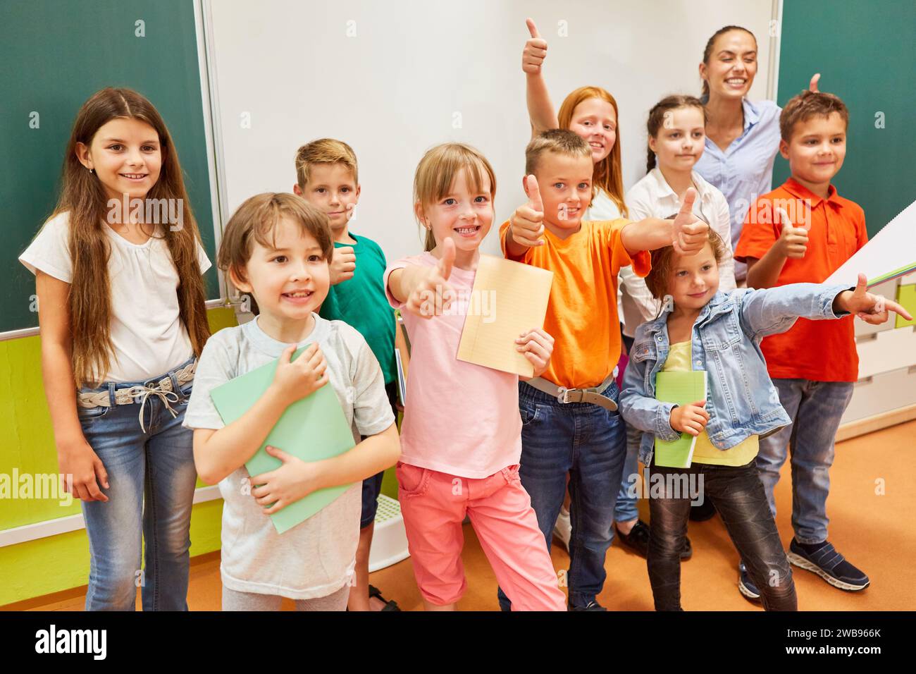 Portrait of happy male and female students showing thumbs up gesture ...