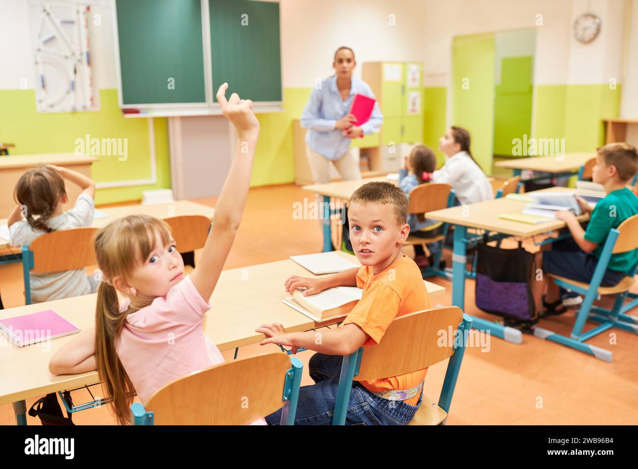 Portrait of school children sitting on chair during lecture in ...