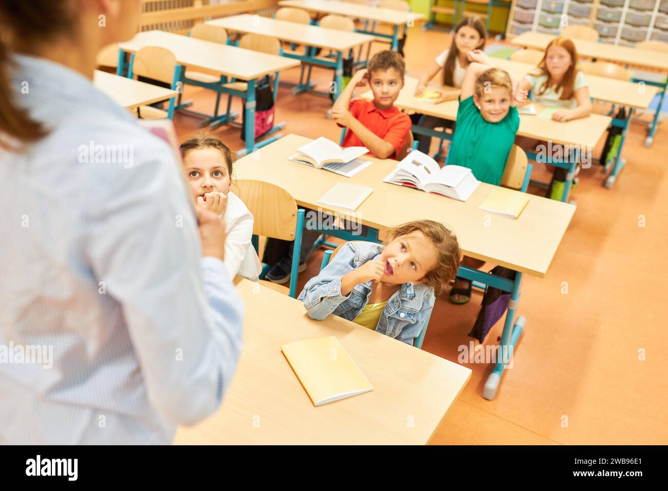 High angle view of schoolkids sitting on bench while attending lecture ...