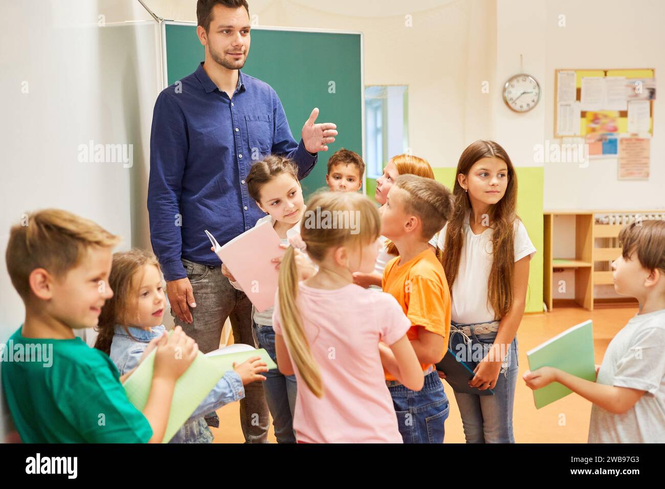 Male and female school students holding books while standing with ...