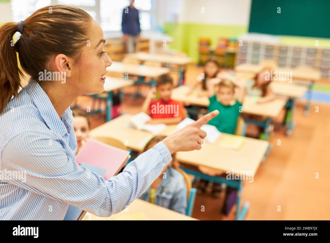 Side view of elementary school teacher pointing during lecture in class ...