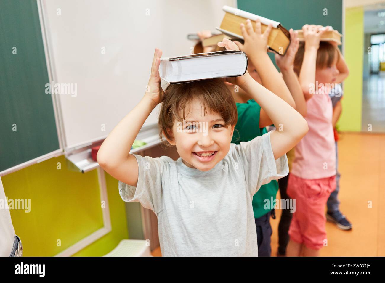 Portrait of smiling schoolgirl holding book overhead while standing ...
