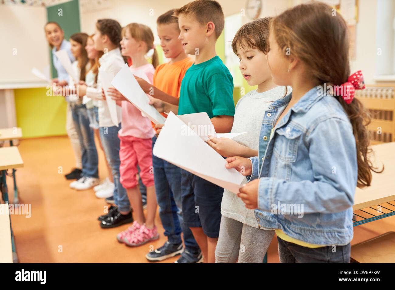 Students standing in row during choir practice in classroom at school ...