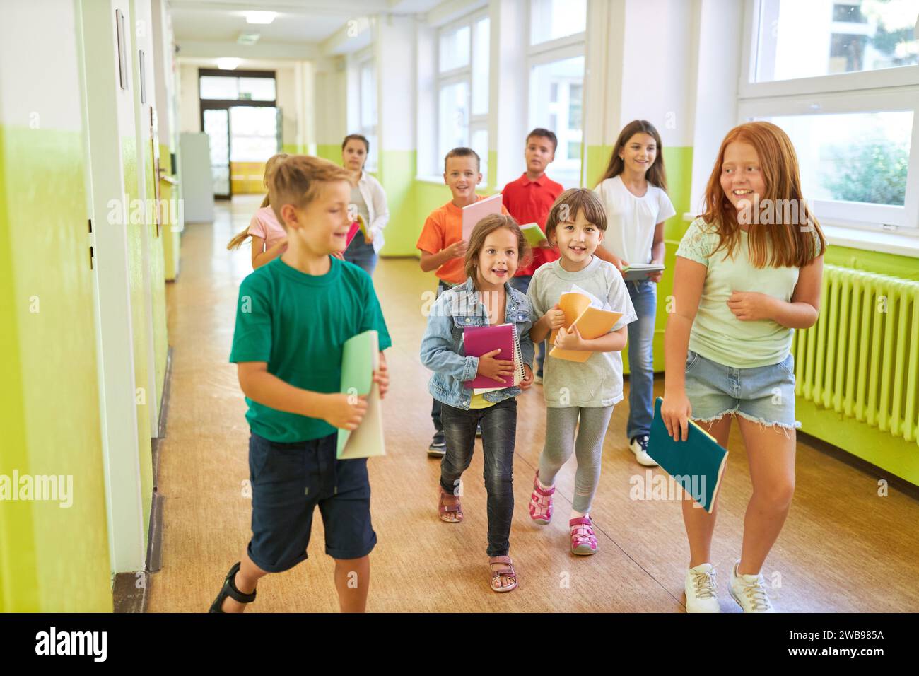 Group of elementary school students walking together in hallway Stock Photo - Alamy