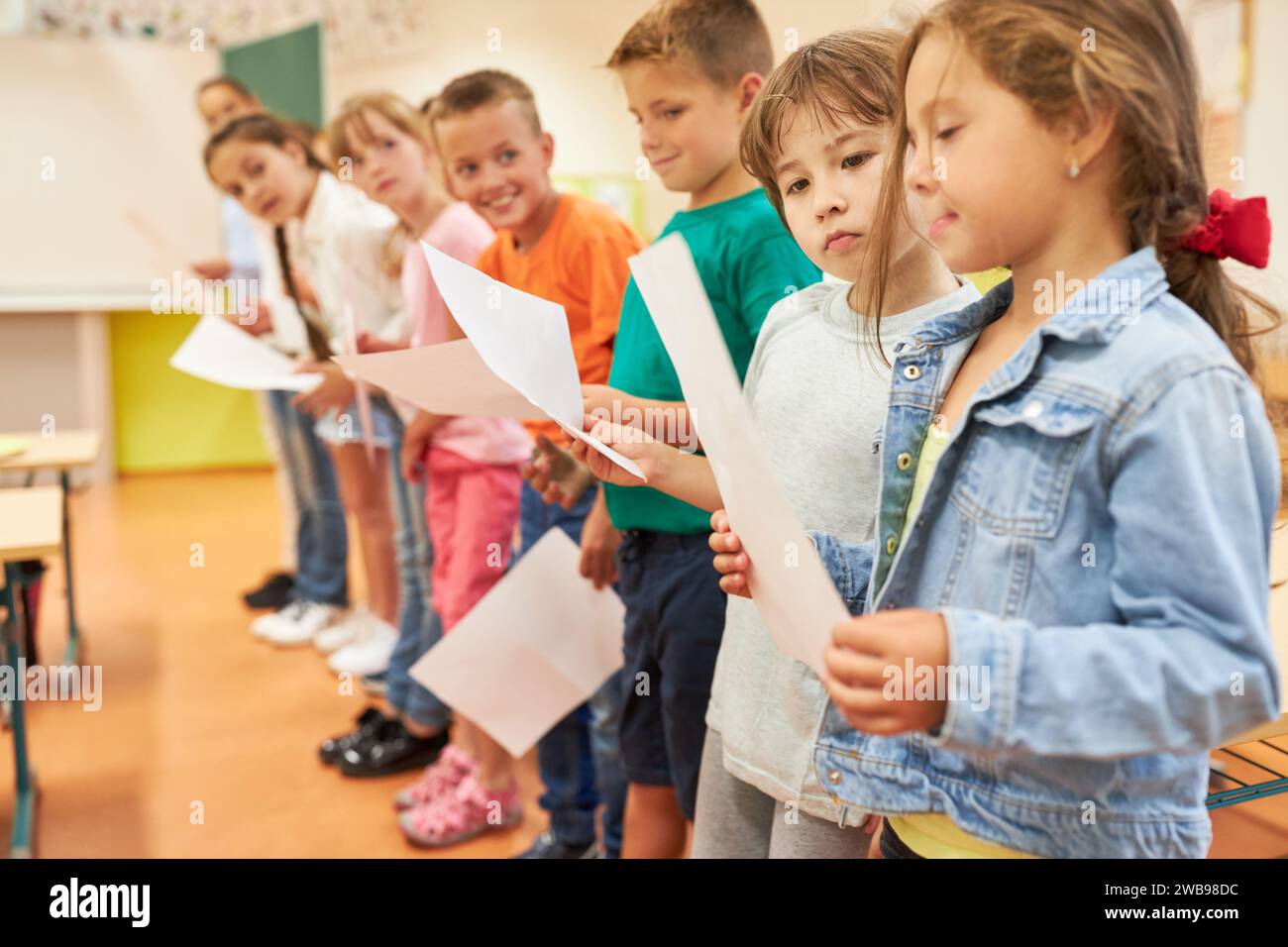Schoolkids holding sheet while standing in row during choir practice in ...
