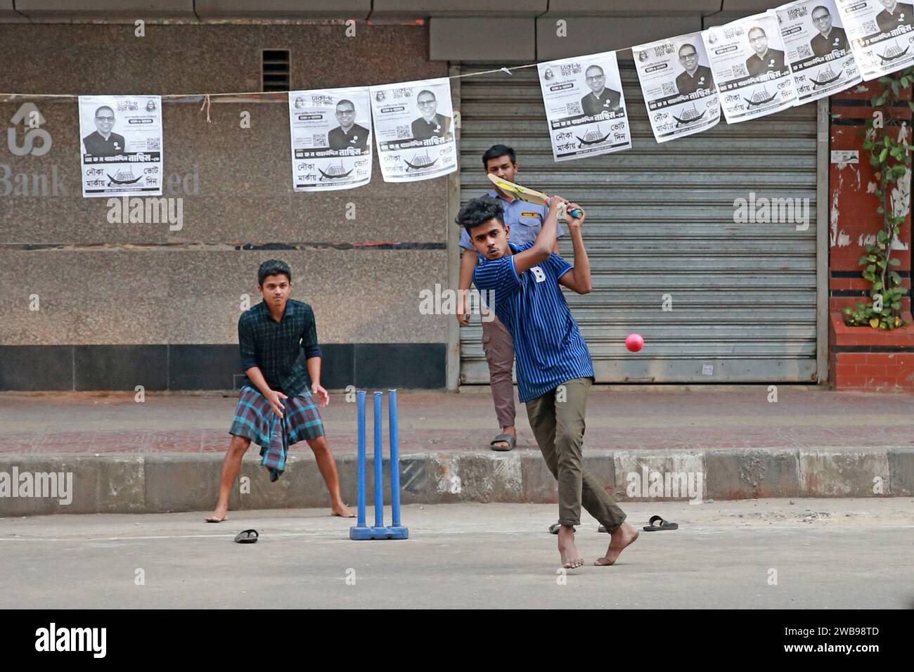 A group of youth playing cricket on city business hub Dilkusha street ...