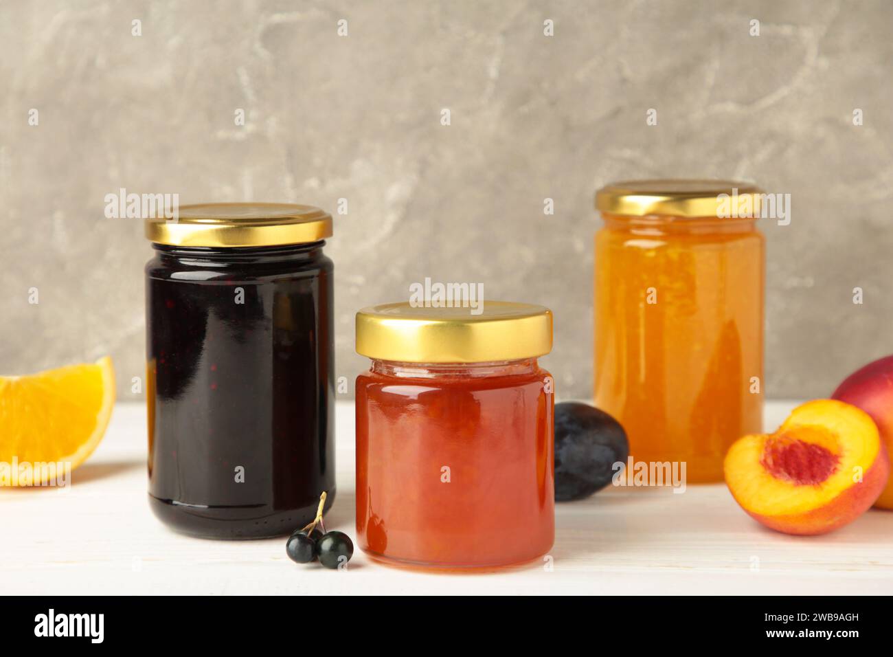 Homemade fruit jam in the jar with fresh fruit and berries on grey ...