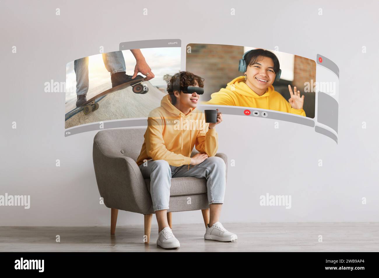 Young cheerful asian guy communicating with friend via VR headset ...