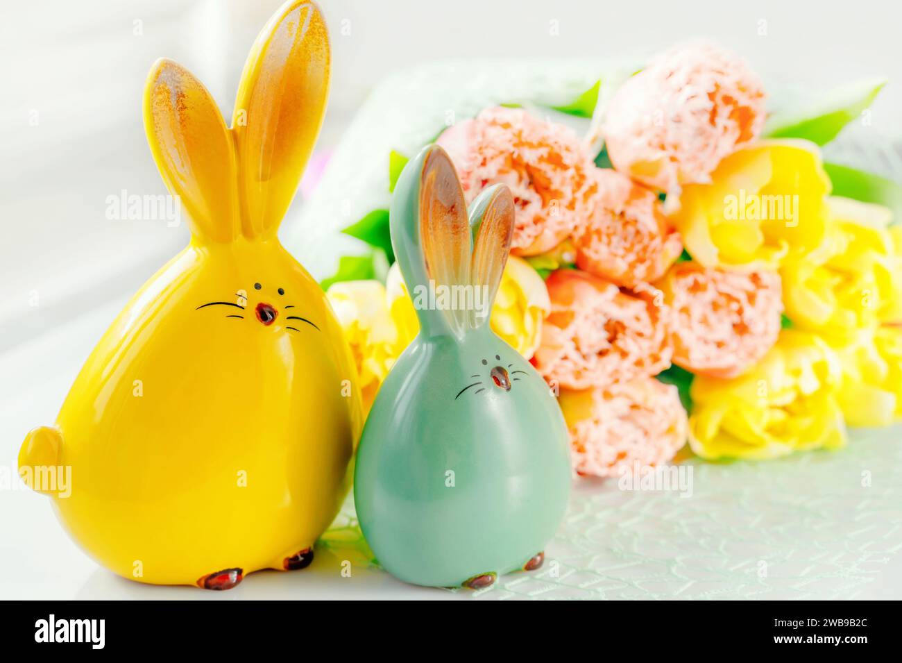 Easter bunny figures in an Easter composition. Yellow and red tulips ...
