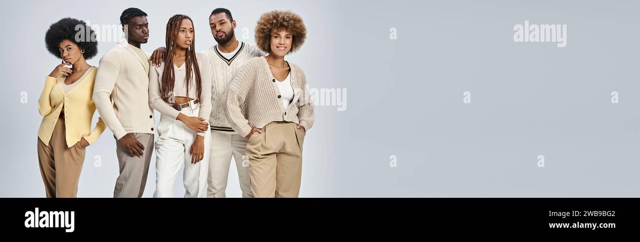 stylish african american people in casual attire standing on grey ...